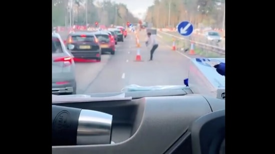 Drivers get out of cars to remove traffic cones to help clear road for ...
