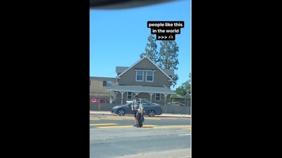 Man gets out of car to help elderly woman cross road at a traffic ...