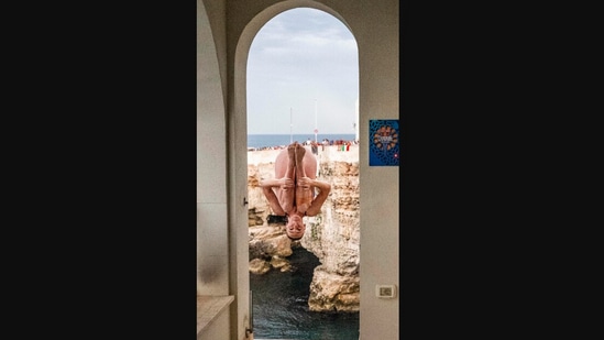 Professional diver beautifully dives into waterbody from balcony in ...