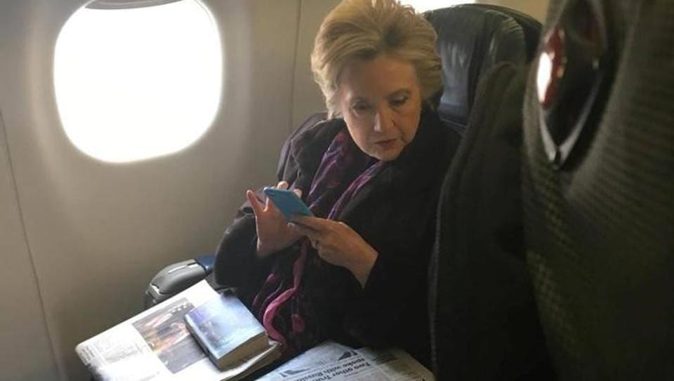 Photo of Hillary Clinton reading Mike Pence email story in newspaper ...