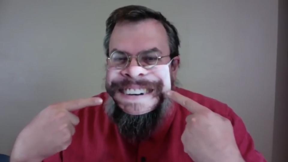 Professor Steve Butler tries on a mask with half of his face printed on ...
